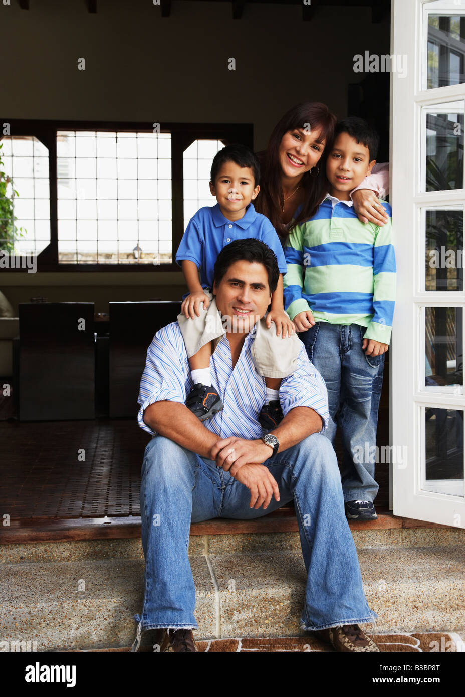 Hispanic family hugging in doorway Stock Photo - Alamy