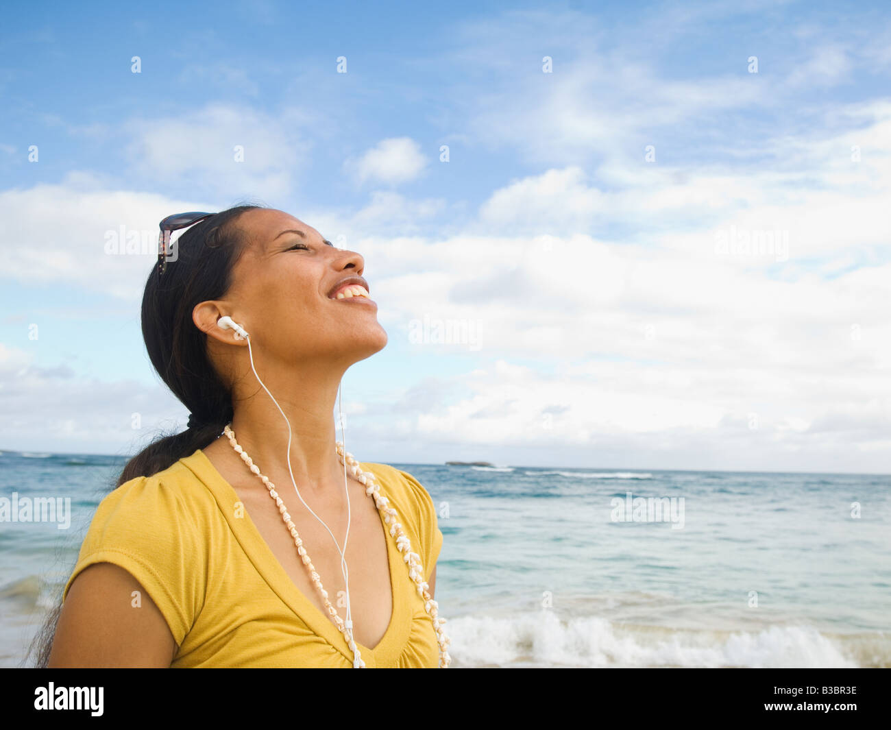 Pacific Islander woman listening to mp3 player Stock Photo - Alamy