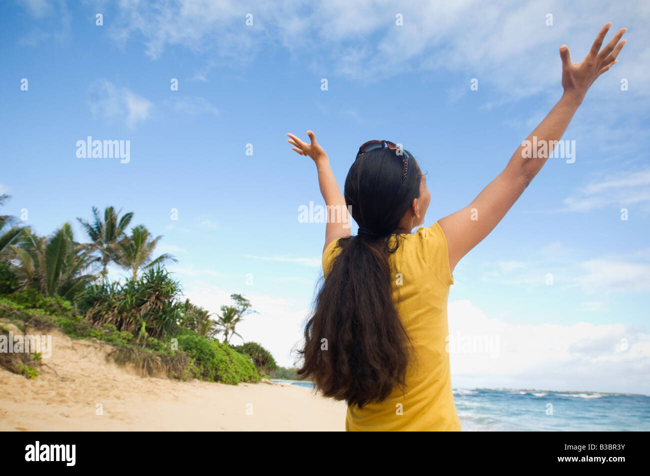 Pacific Islander woman with arms raised at beach Stock Photo - Alamy