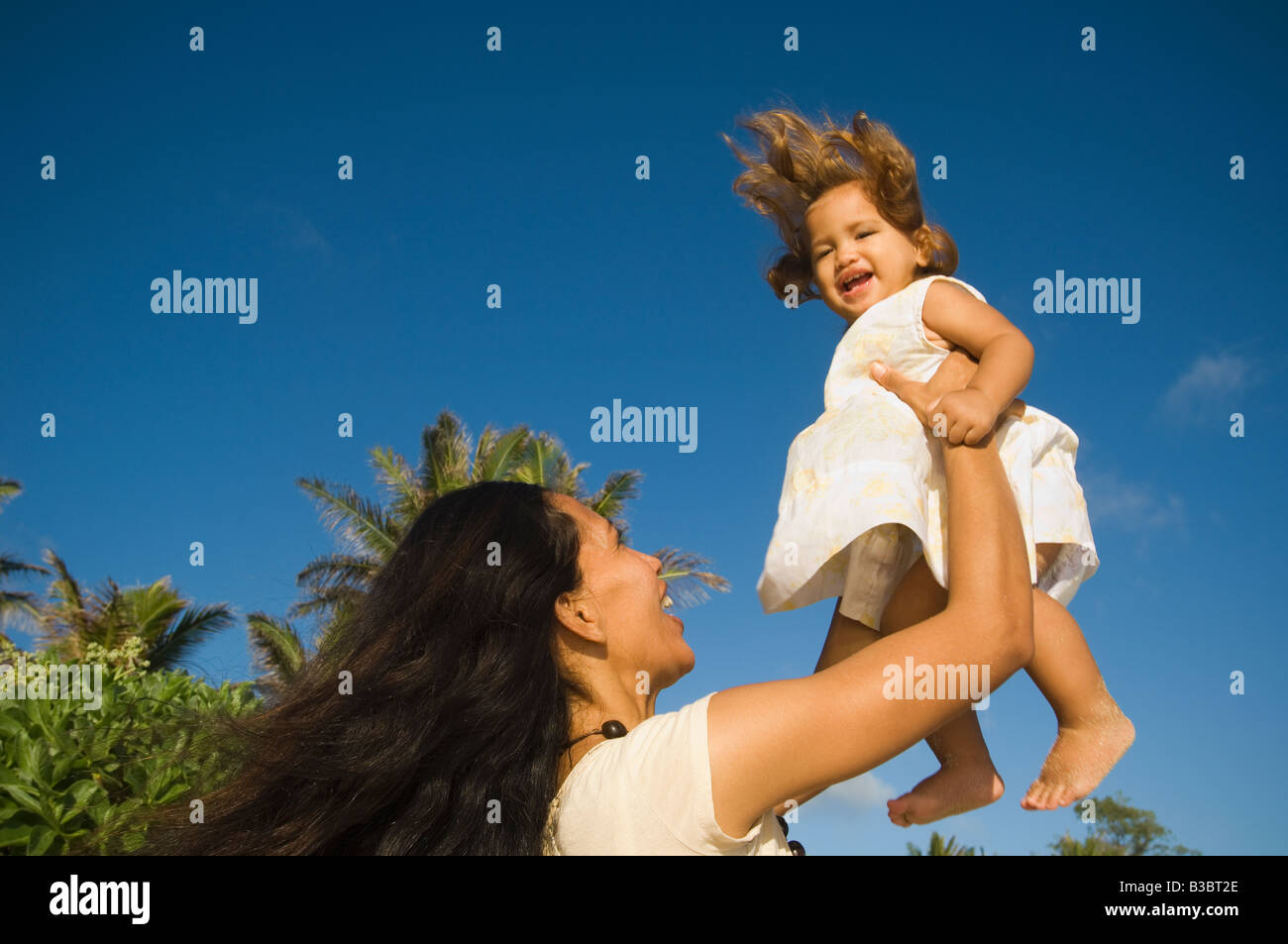 Pacific Islander mother holding daughter in air Stock Photo - Alamy