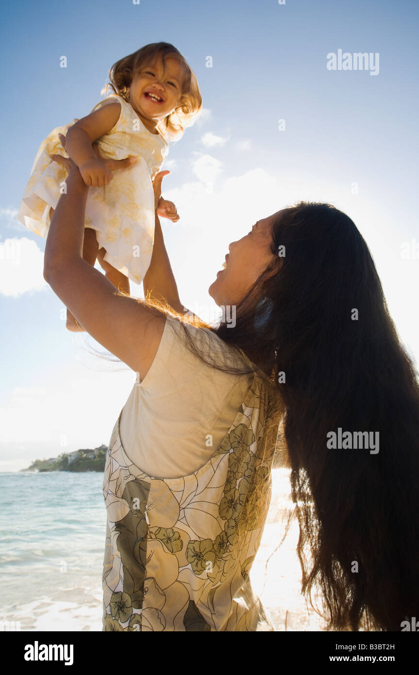 Pacific Islander mother holding daughter in air Stock Photo - Alamy