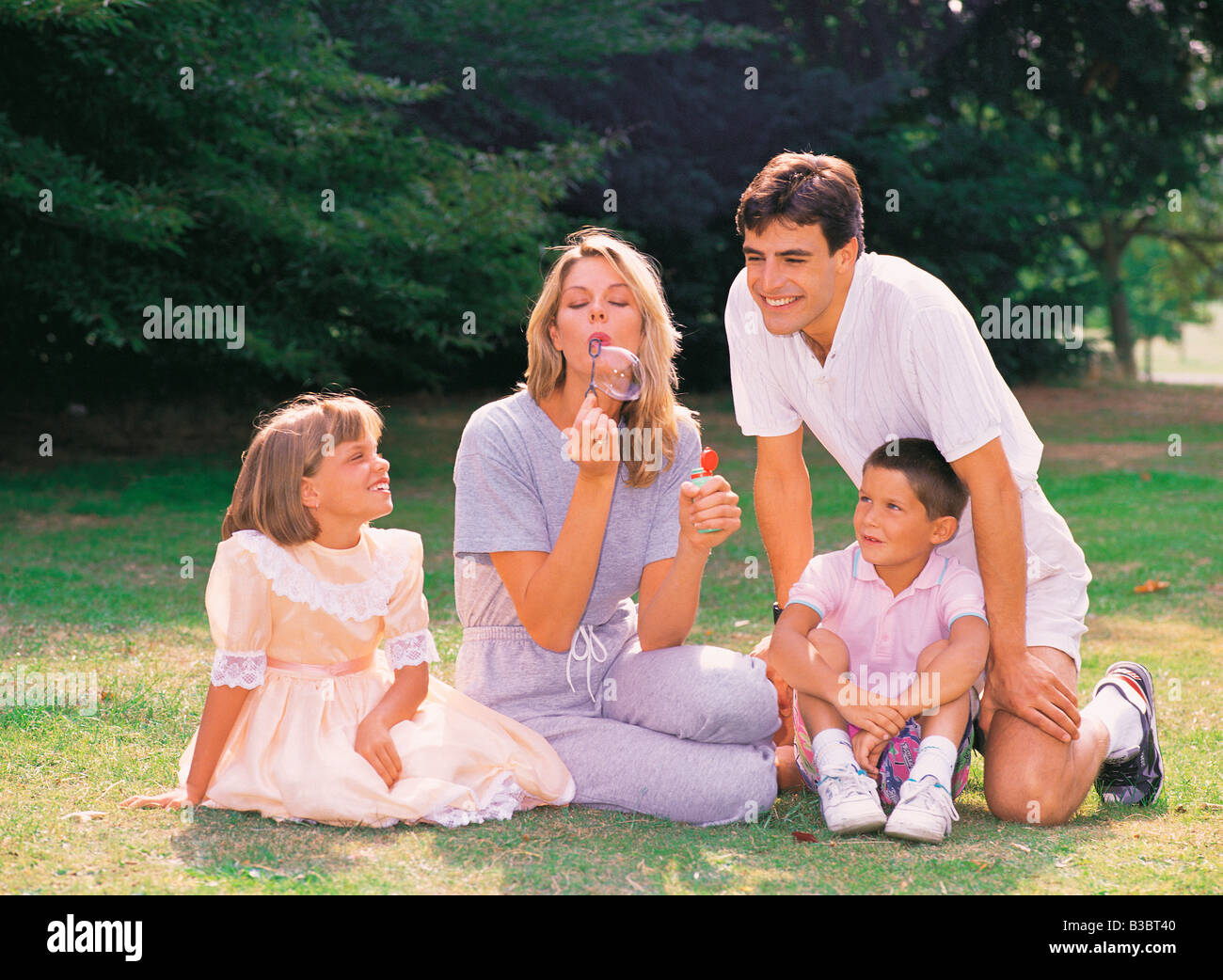 Parents. Man and woman enjoying free time with two children in a park ...