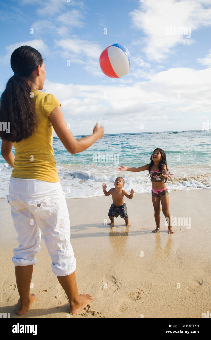 Pacific Islander mother and children playing with beach ball Stock ...