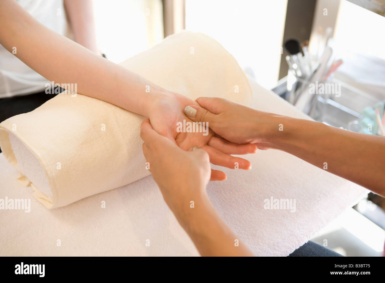 Young woman massaging hands Stock Photo - Alamy