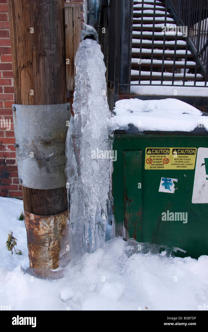 Ice has frozen to the ground on a waterspout in a back alley Stock ...
