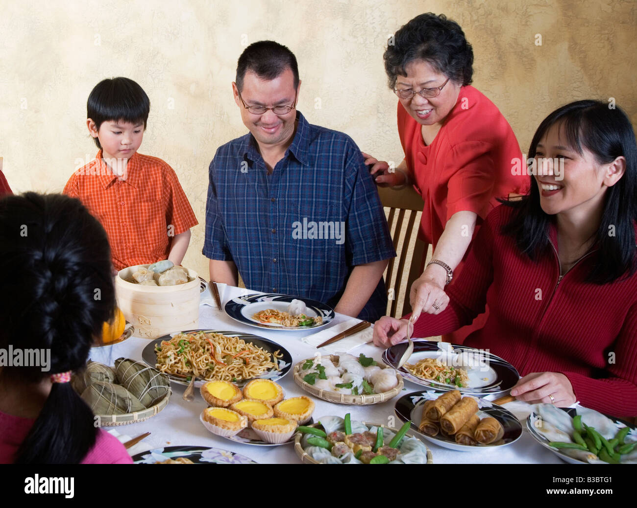 Asian family eating at dinner table Stock Photo - Alamy