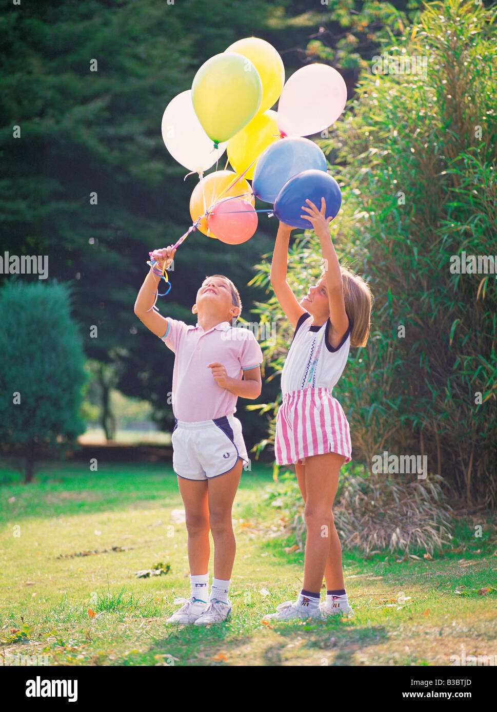 Children playing with balloons in a park Stock Photo - Alamy
