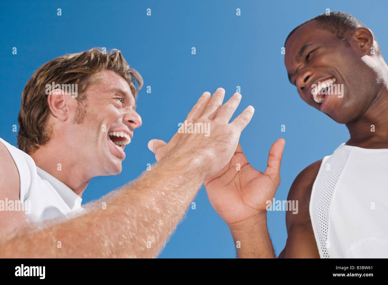 Multi-ethnic men high-fiving Stock Photo - Alamy
