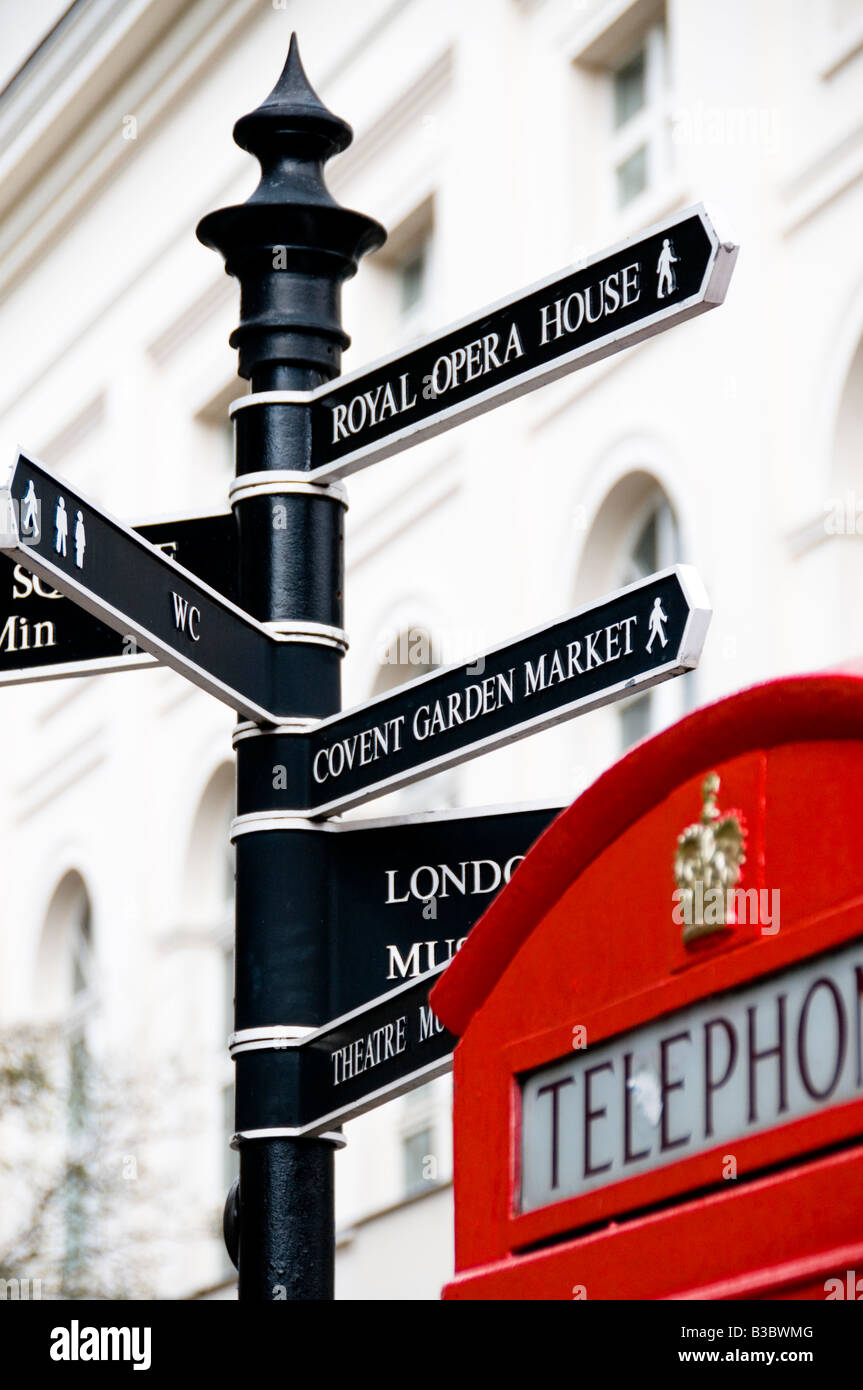 a signpost and a red telephone booth in London, England Stock Photo - Alamy