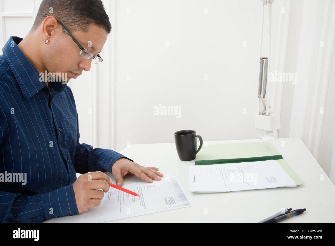 Hispanic man reading paperwork Stock Photo - Alamy