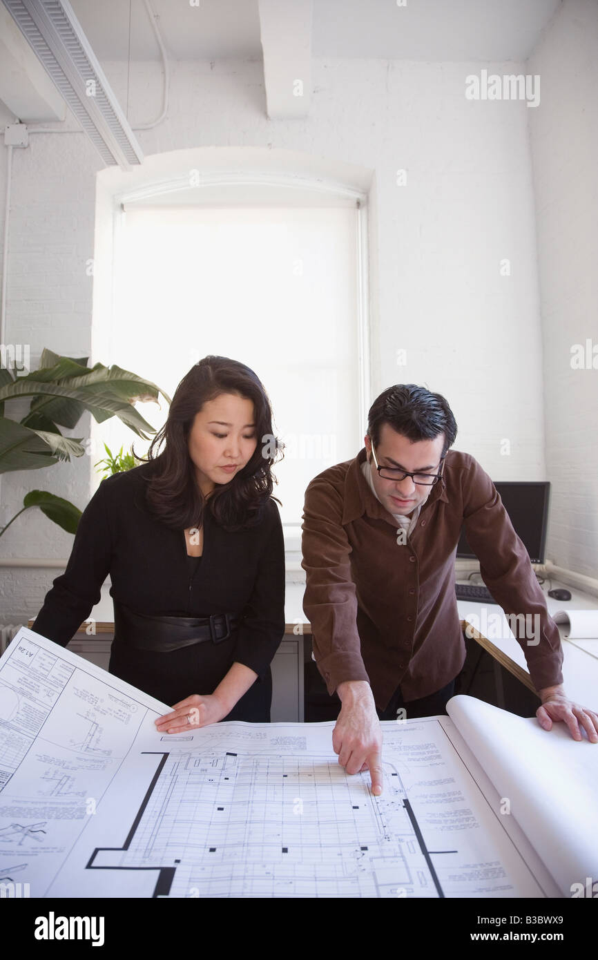 Multi-ethnic businesspeople looking at blueprints Stock Photo - Alamy