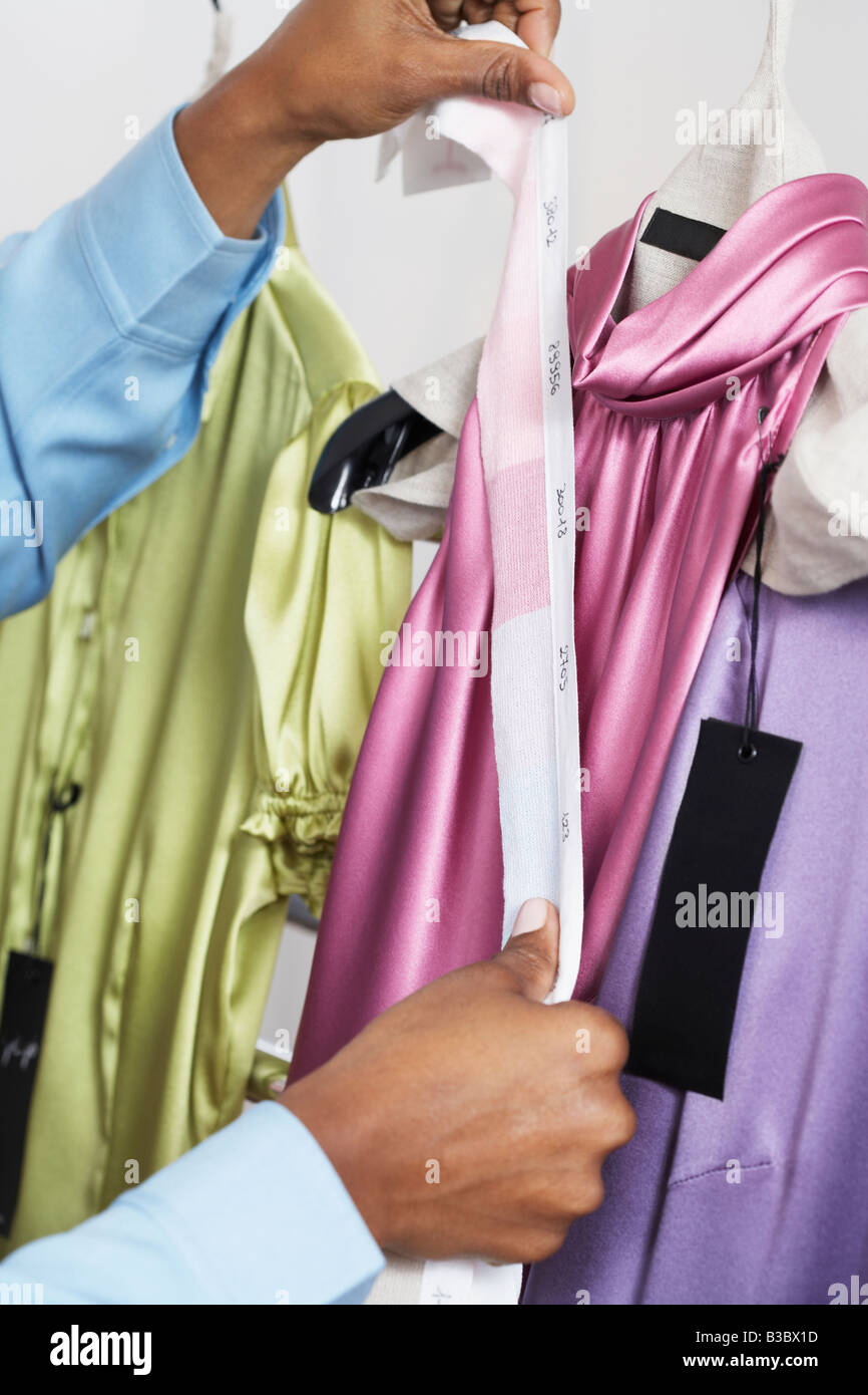 African woman holding fabric swatch against dress Stock Photo - Alamy