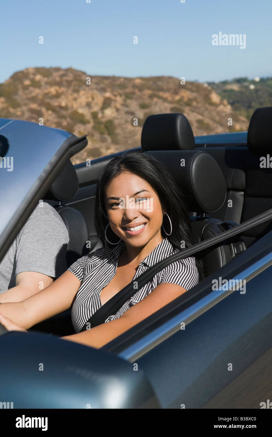 Asian woman driving convertible car Stock Photo - Alamy