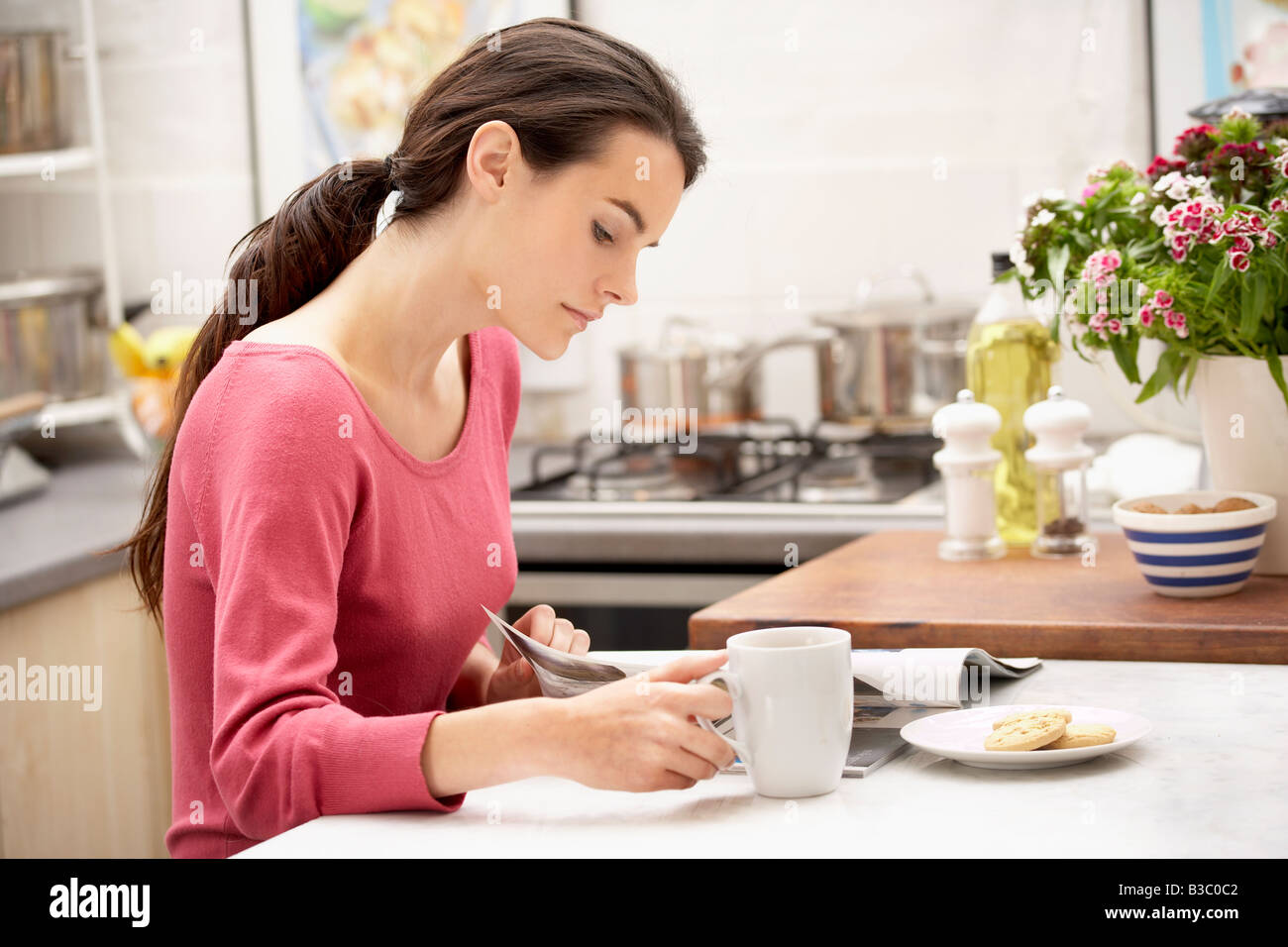 A young woman reading a magazine and drinking coffee Stock Photo - Alamy