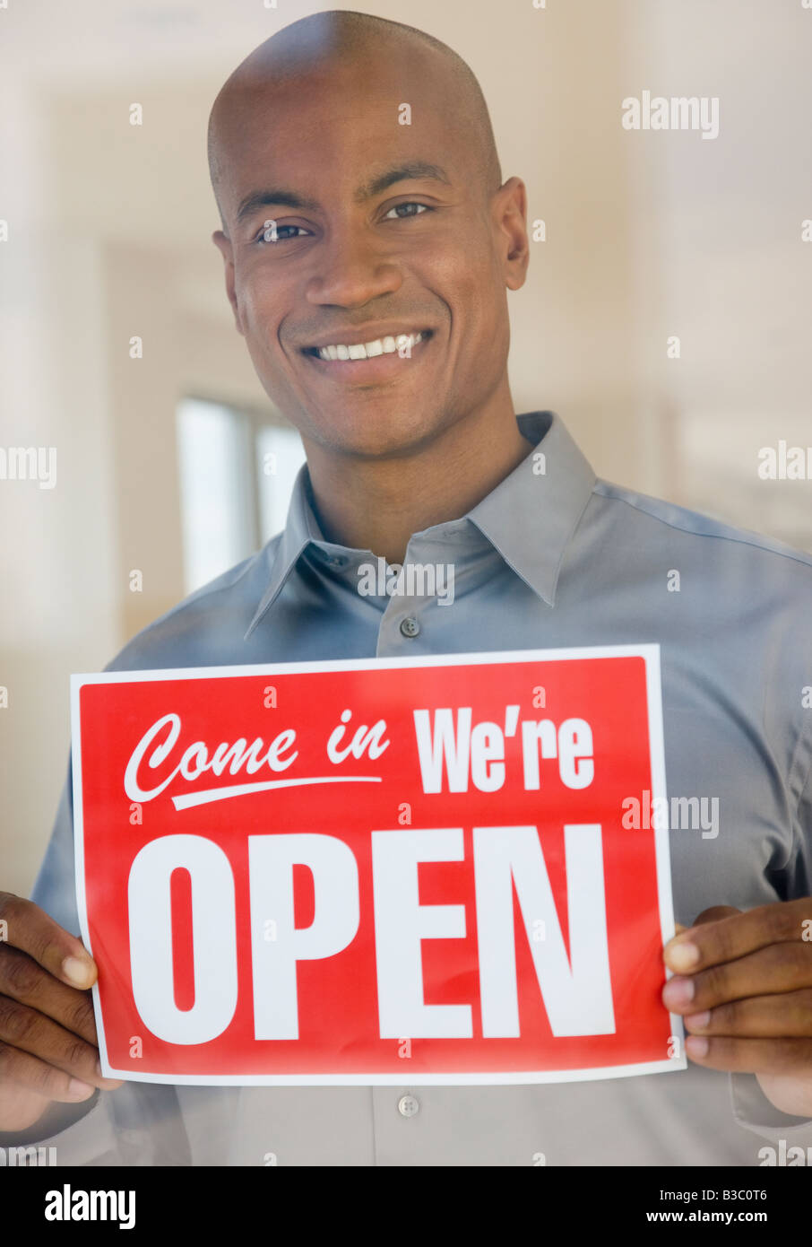 African man holding Open sign Stock Photo - Alamy