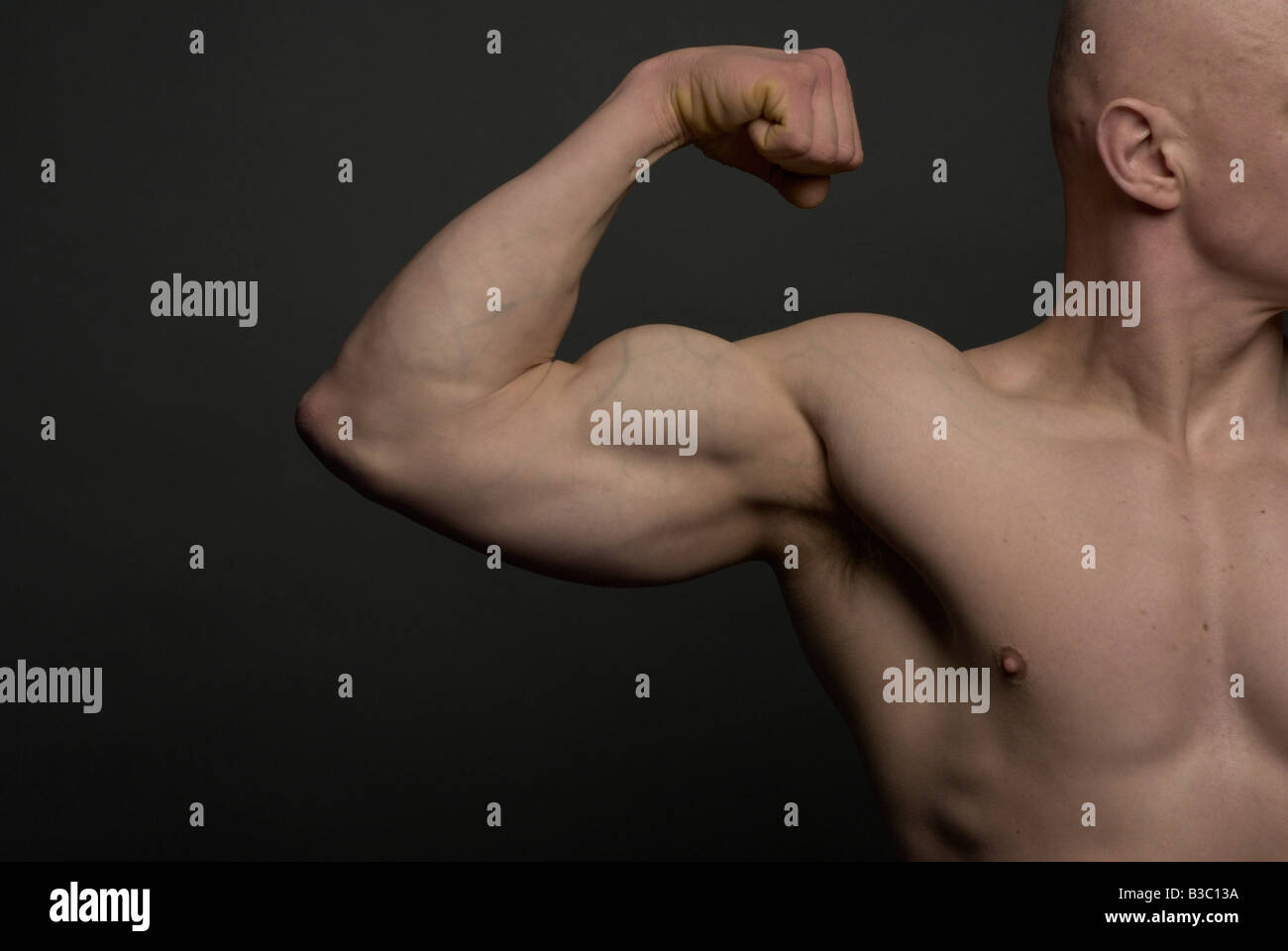 Man tensing bicep muscle hi-res stock photography and images - Alamy