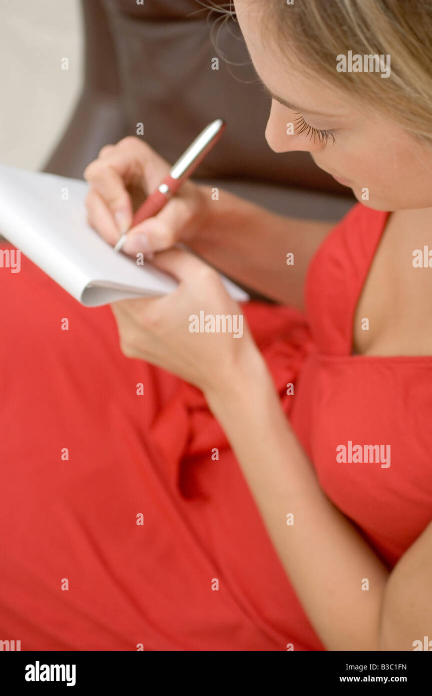 A woman writing in a note pad Stock Photo - Alamy