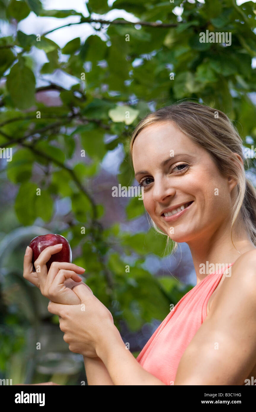 A woman eating an apple from a tree Stock Photo - Alamy