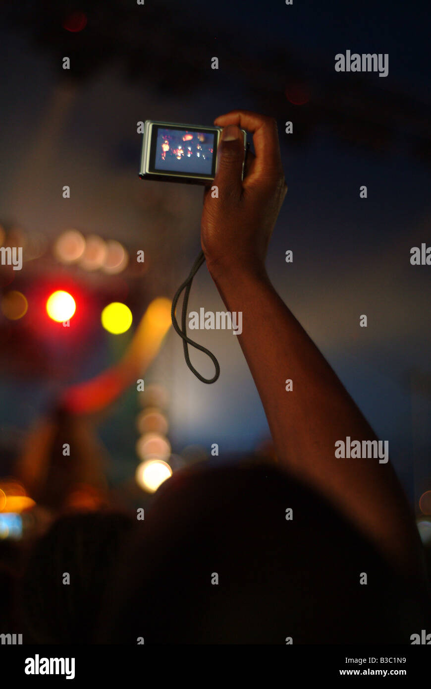 A hand holding up camera to take photo at festival Stock Photo - Alamy