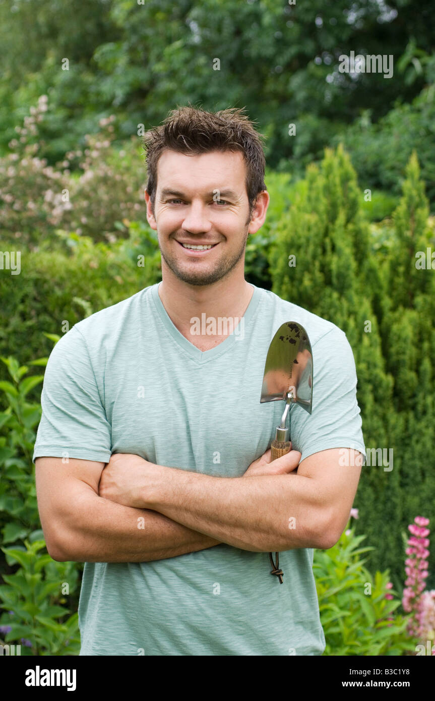 A man standing in a garden with a trowel Stock Photo - Alamy