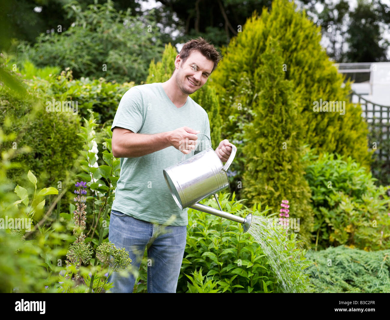 Man watering the plants hi-res stock photography and images - Alamy