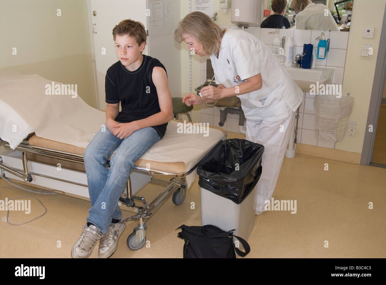 Nurse giving a young boy an injection in his arm Stock Photo - Alamy