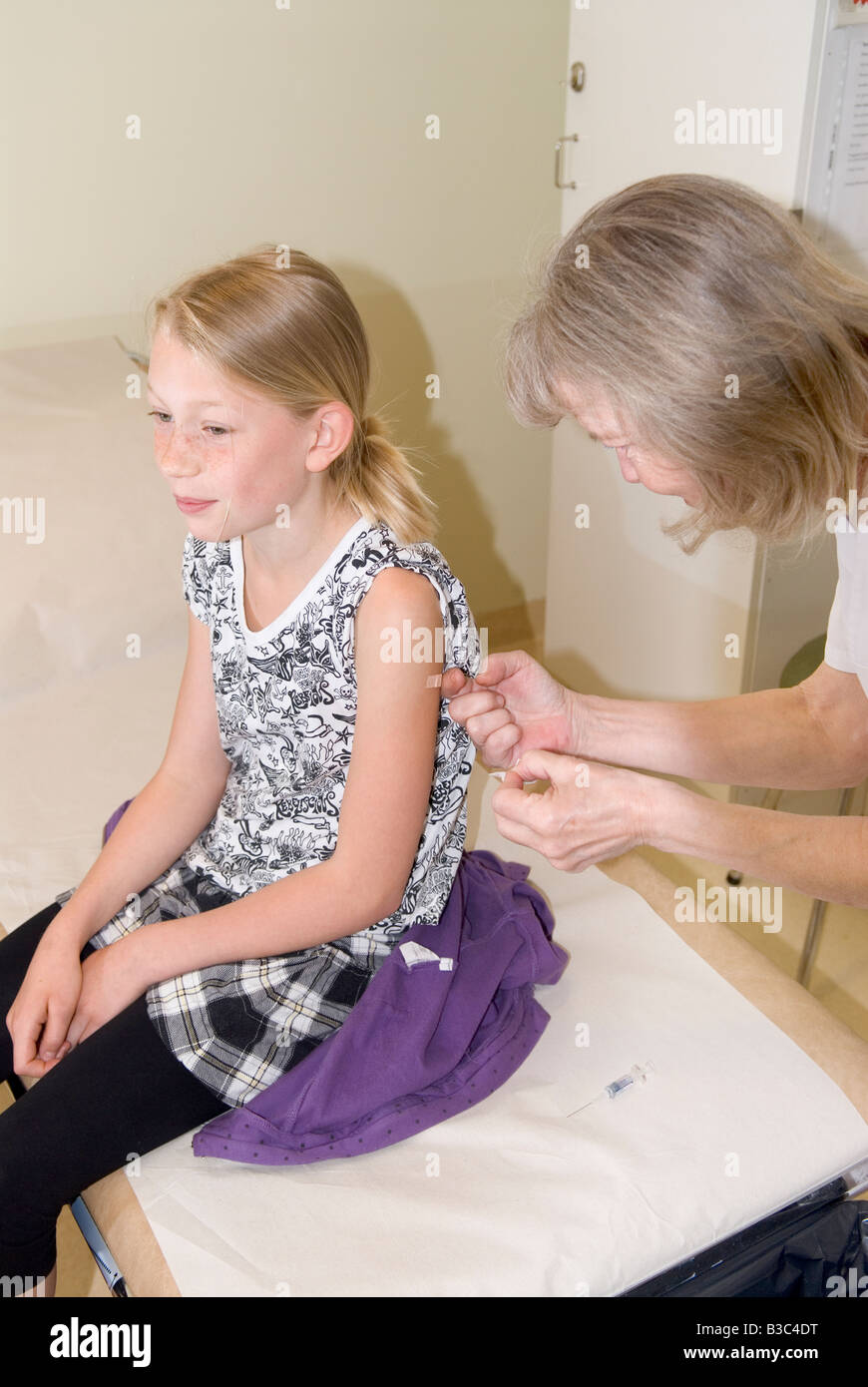 Nurse giving a young girl an injection in her arm Stock Photo - Alamy