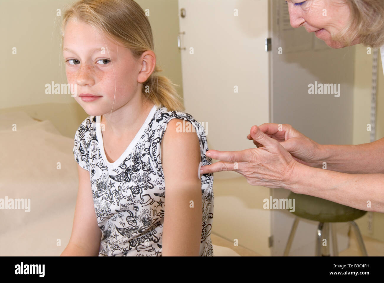 Nurse giving a young girl an injection in her arm Stock Photo - Alamy