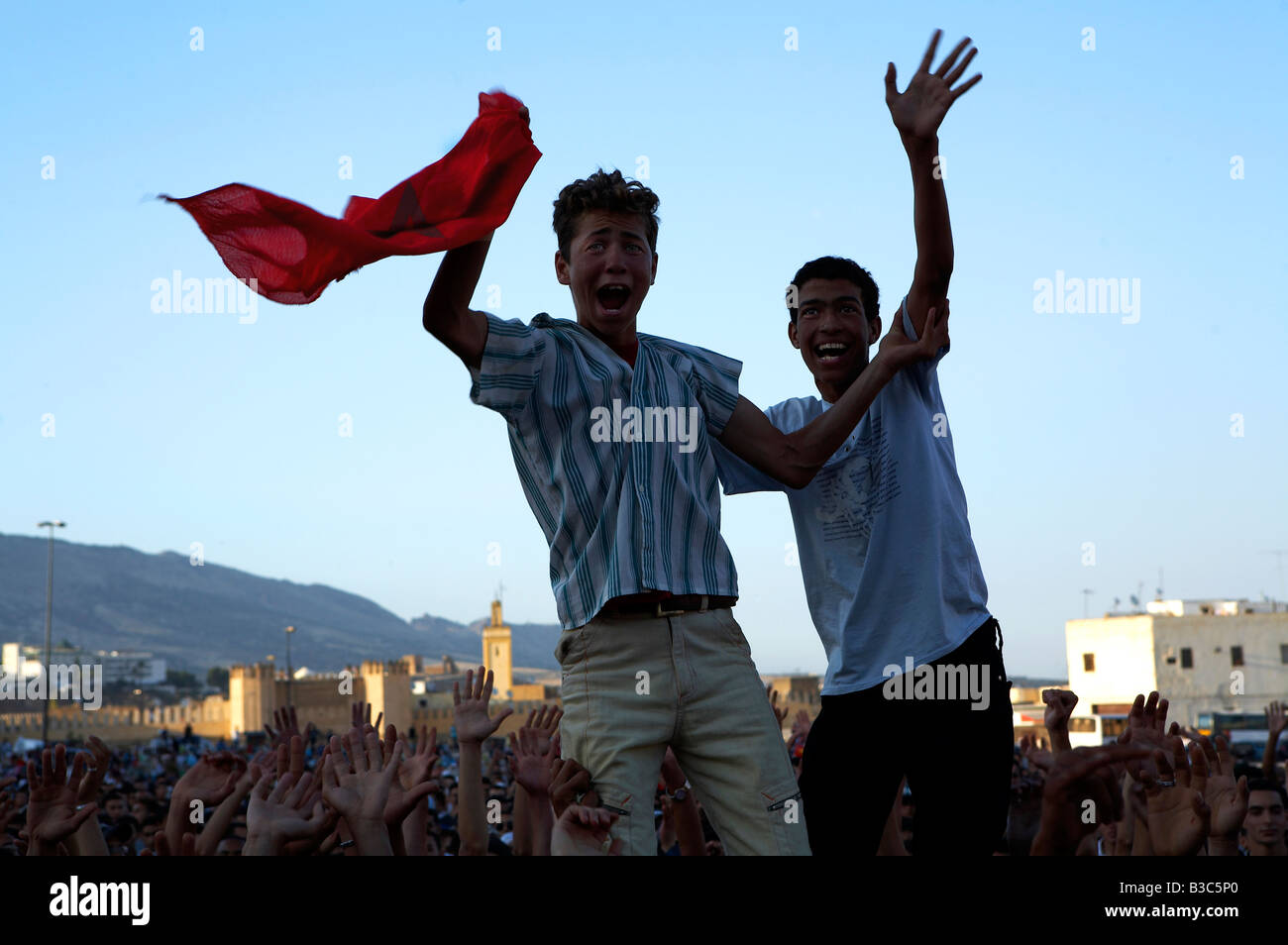 Morocco, Fes. Two proud Moroccan boys wave their national flag above ...
