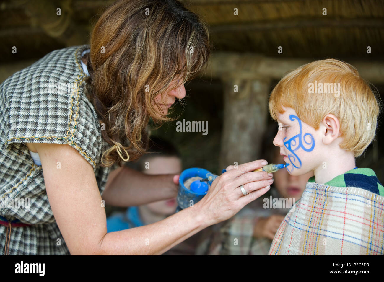 UK, Wales, Pembrokeshire. A young boy has his face painted with woad ...