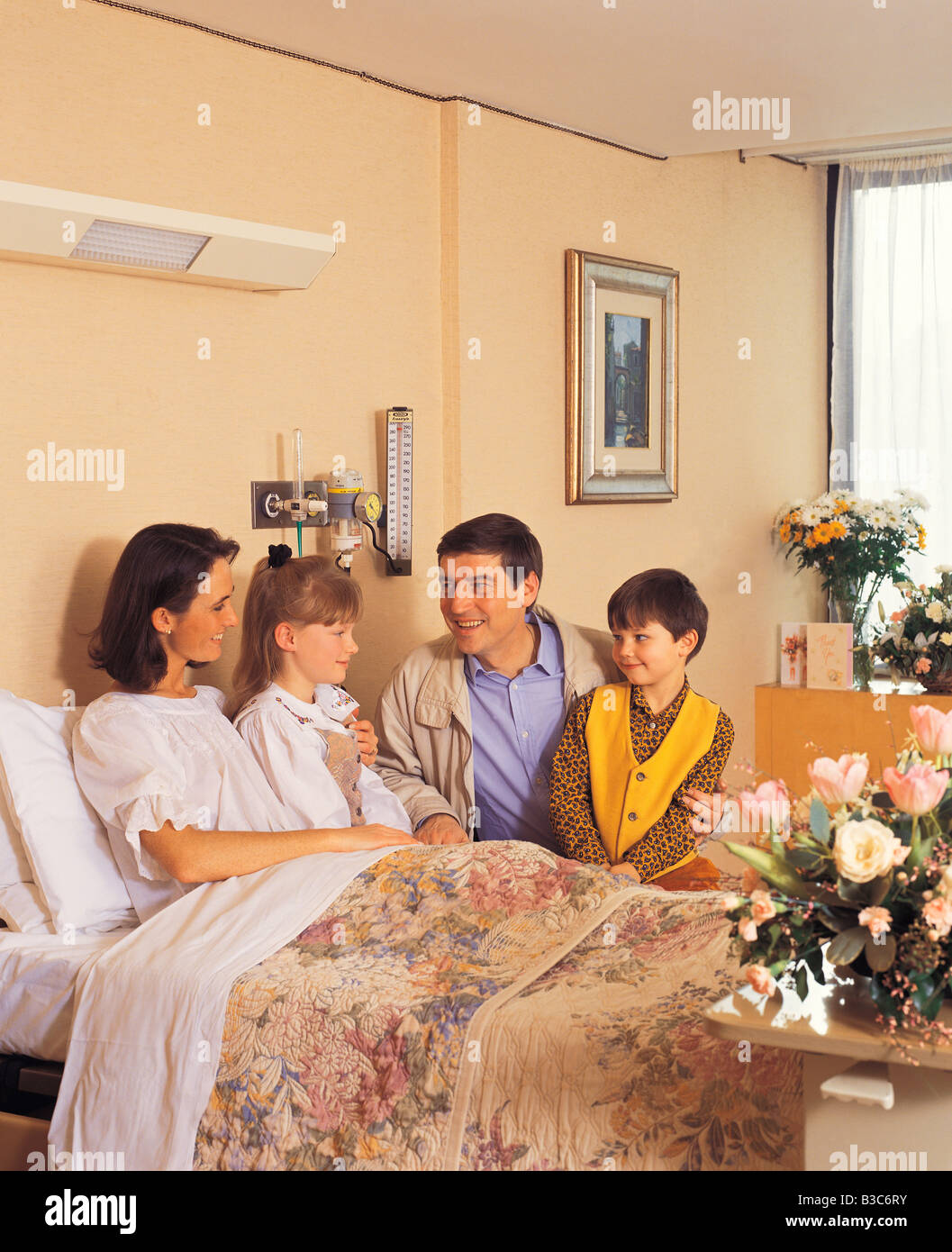 Hospital. Father and children visiting mother in bed Stock Photo - Alamy