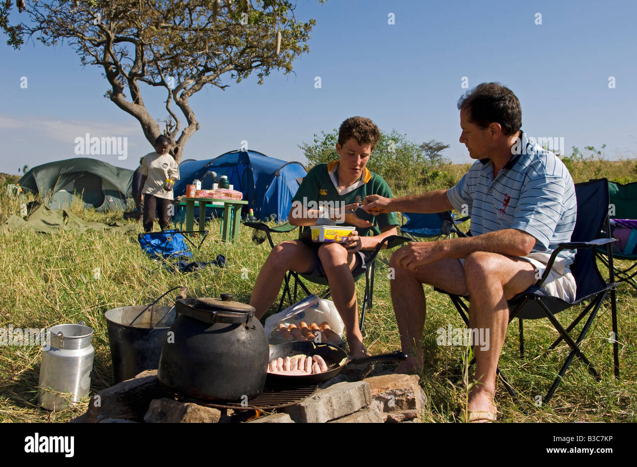 Kenya, Masai Mara National Reserve. Cooking breakfast at camp along the ...