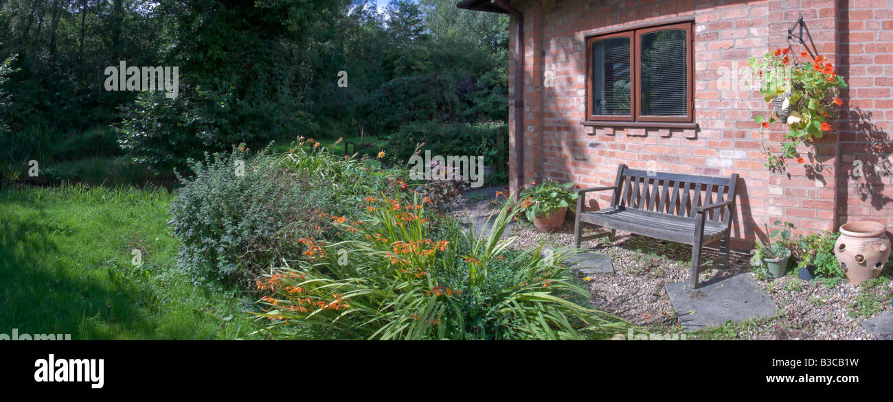 a cottage garden with a bench Stock Photo - Alamy