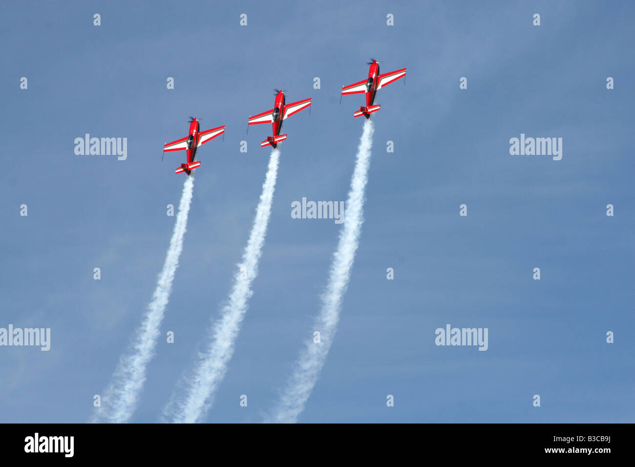three aircraft climbing vertically in formation with smoke trails ...