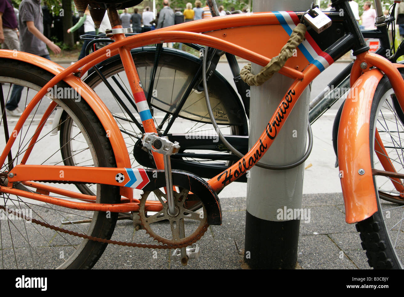 Orange typical dutch shape orange one bicycle locked to streetligtht ...