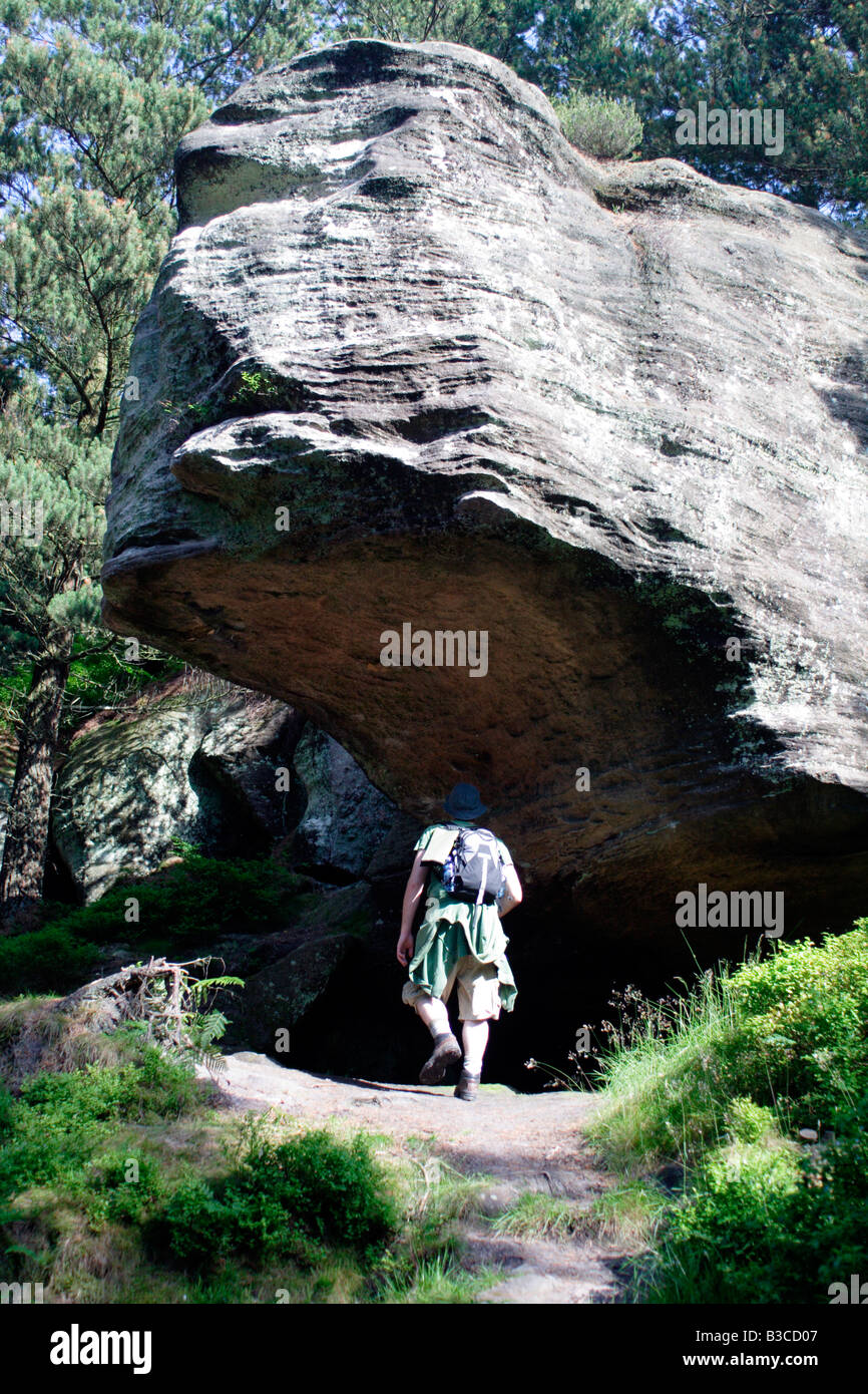A walker at a rocky outcrop along the Simonside Ridge walk ...