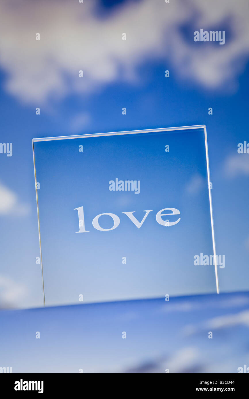 the word love etched in glass on a sky background Stock Photo - Alamy