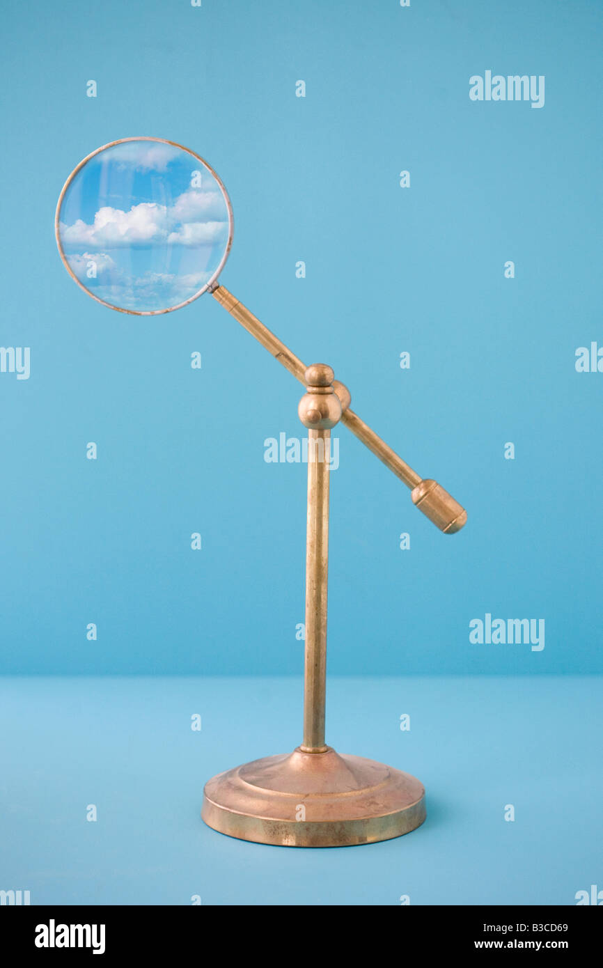 magnifying glass with clouds on sky blue background Stock Photo - Alamy