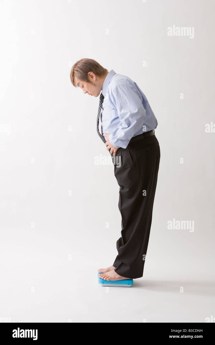 Fat man on scale hi-res stock photography and images - Alamy