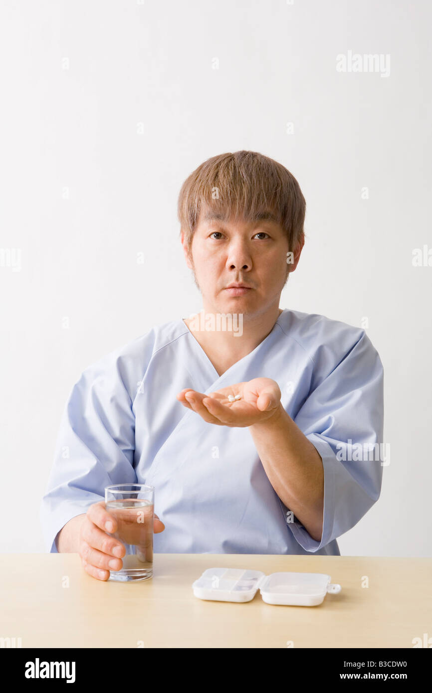 Mid adult man taking pills Stock Photo - Alamy