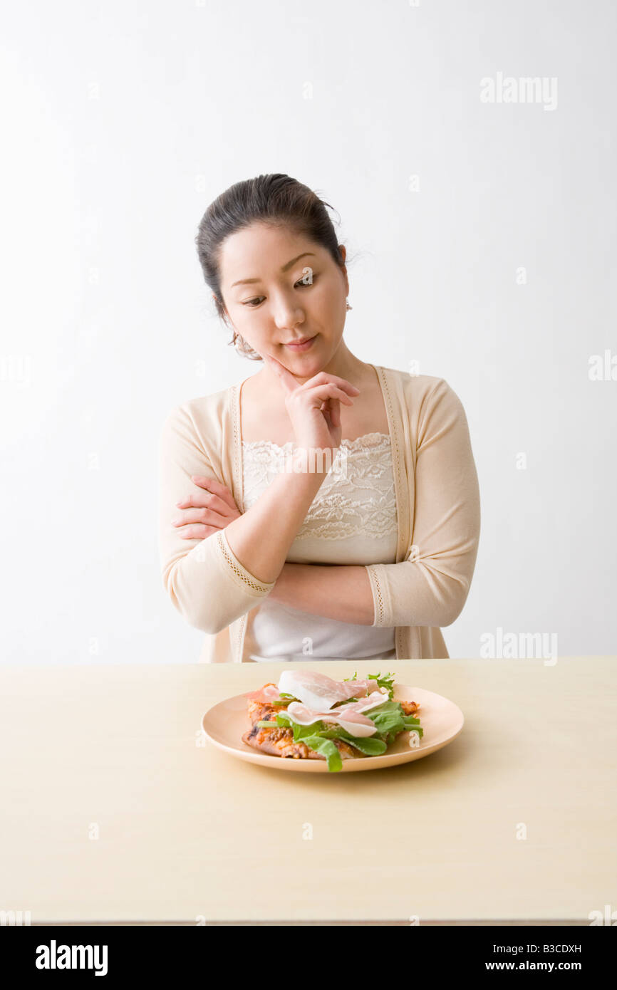 Mid adult woman looking at pizza Stock Photo - Alamy