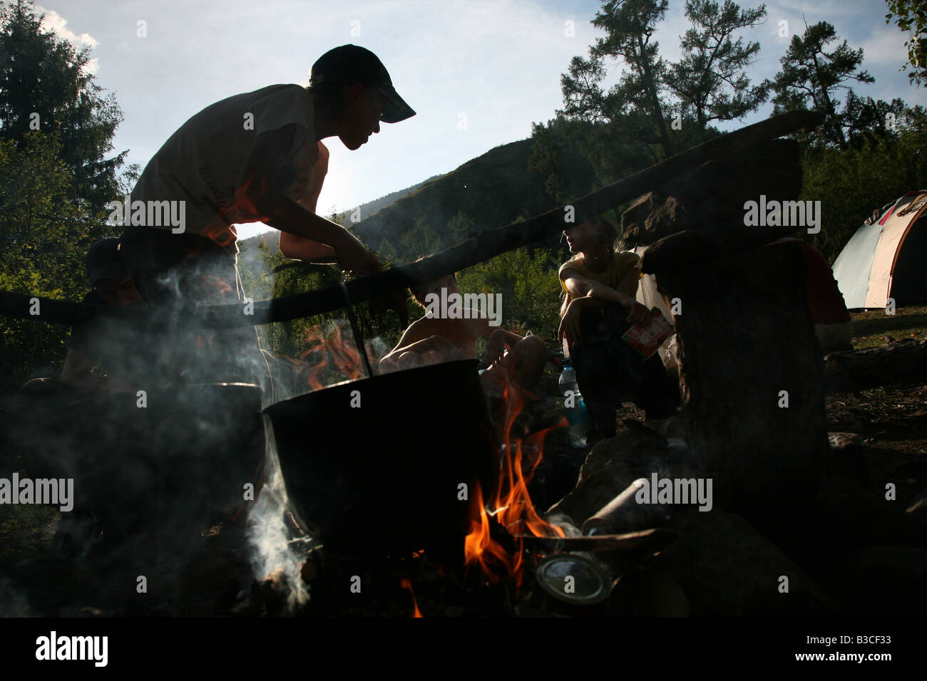 Children cooking on the campfire during a trekking in the Altai ...