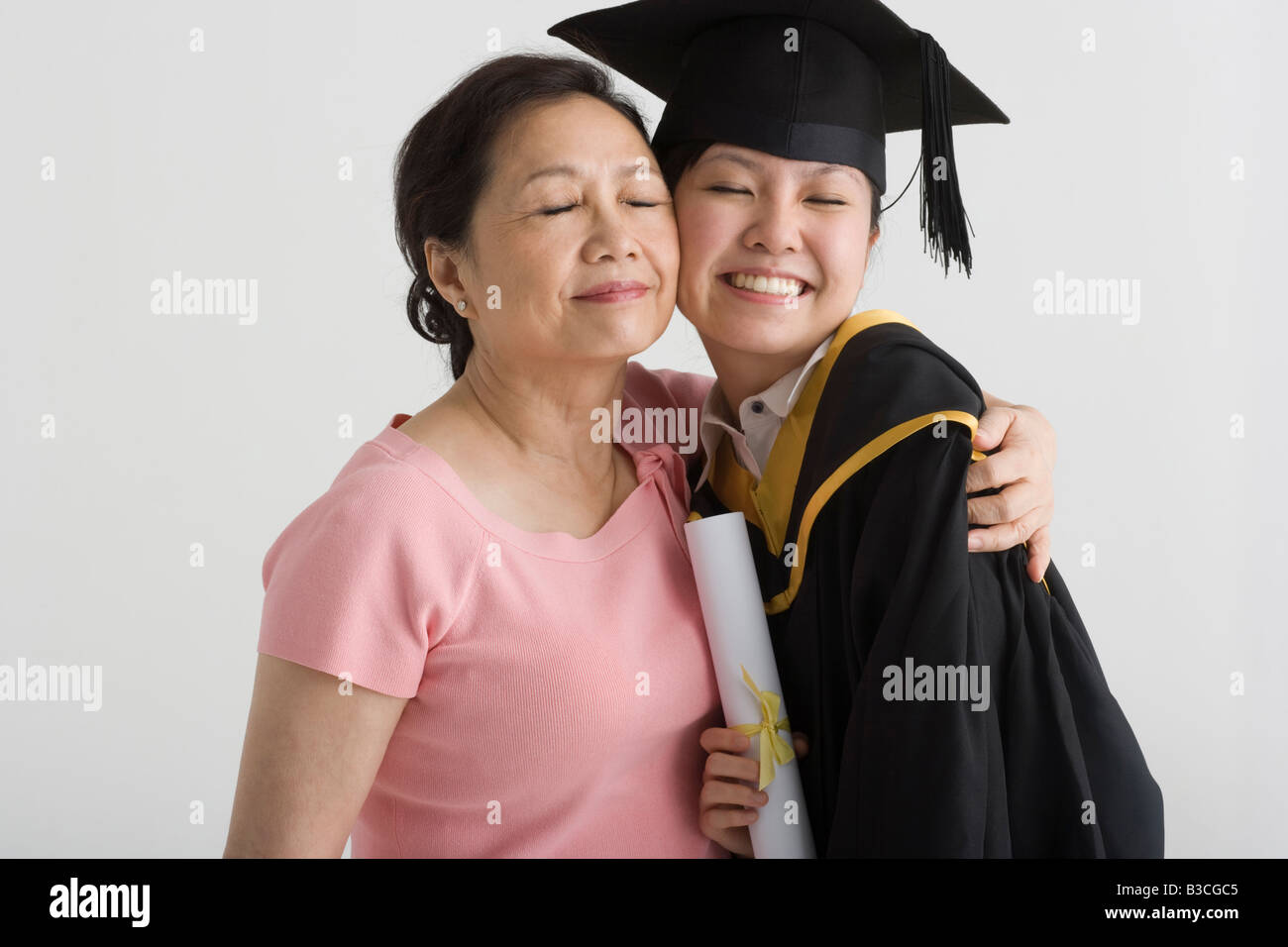 Young female graduate and her mother embracing each other Stock Photo ...