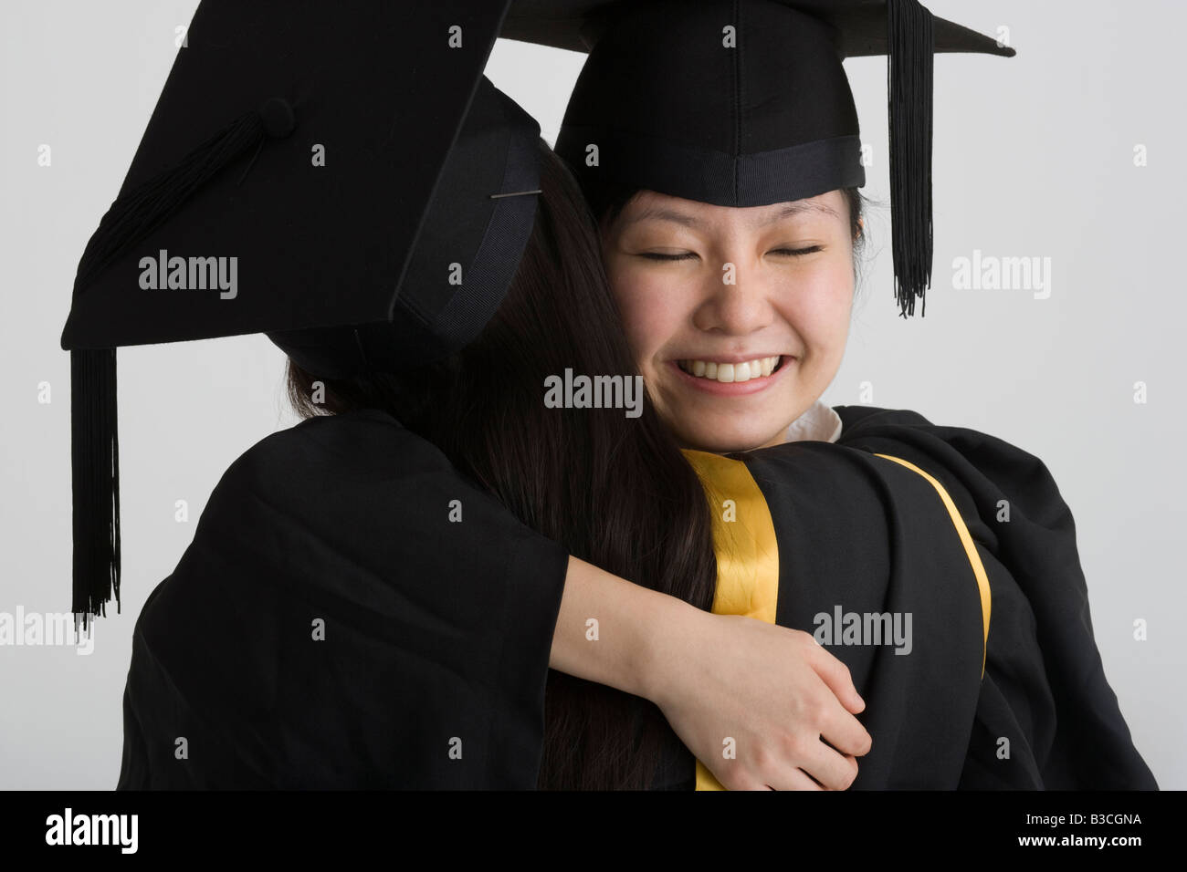 Two female graduates hugging each other and smiling Stock Photo - Alamy