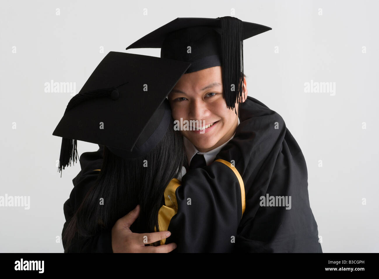Young male graduate hugging a female young graduate and smiling Stock ...