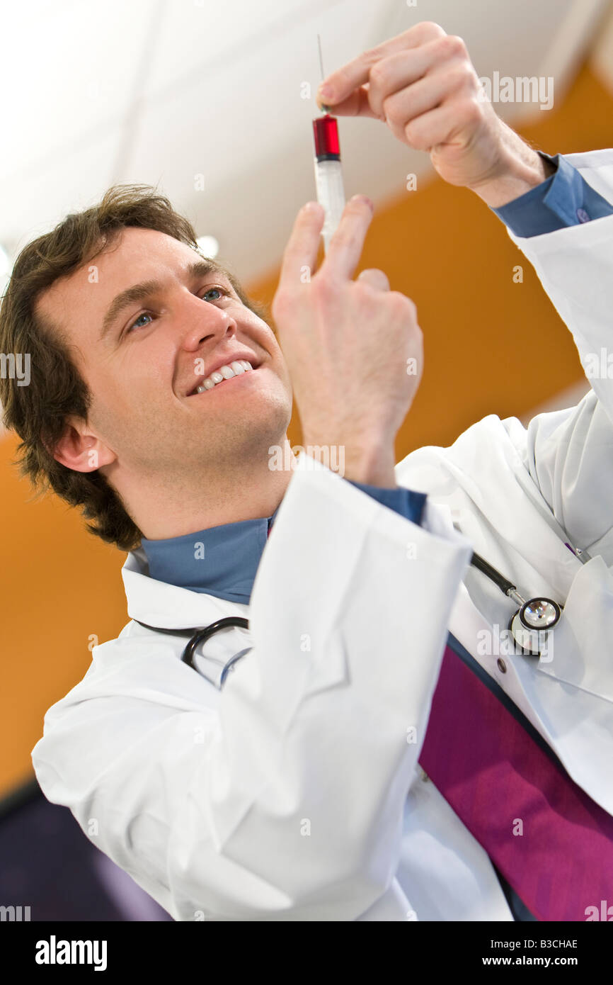 A young male doctor prepares a syringe Stock Photo - Alamy