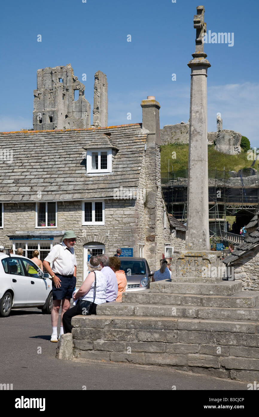 the war memorial in the town of Corfe Castle with the castle in the ...