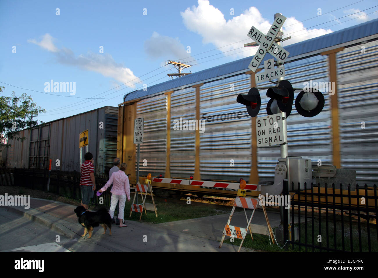 People waiting for freight train to pass railroad crossing in Royal Oak ...