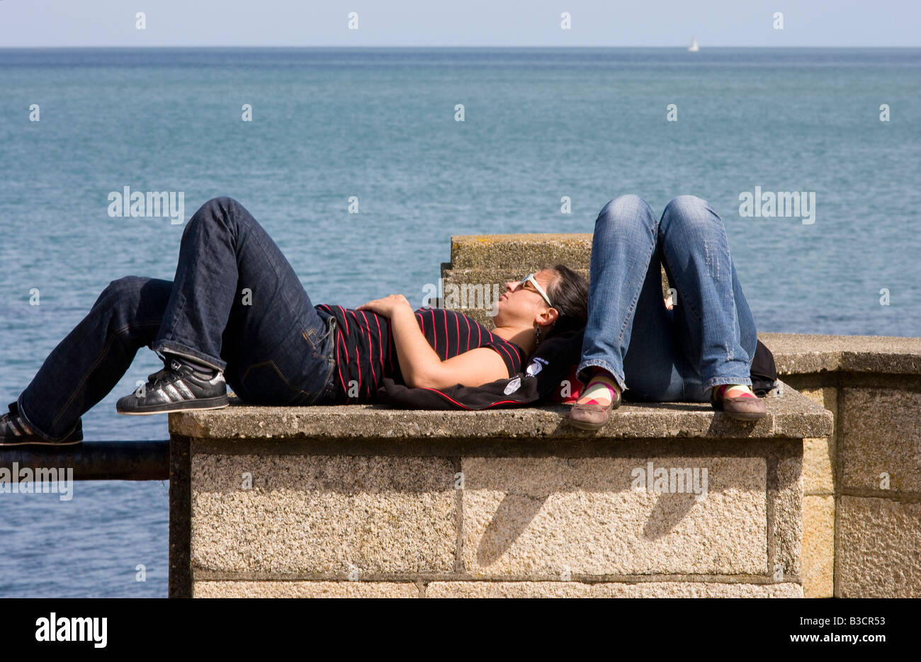 two girls lying on wall Stock Photo - Alamy