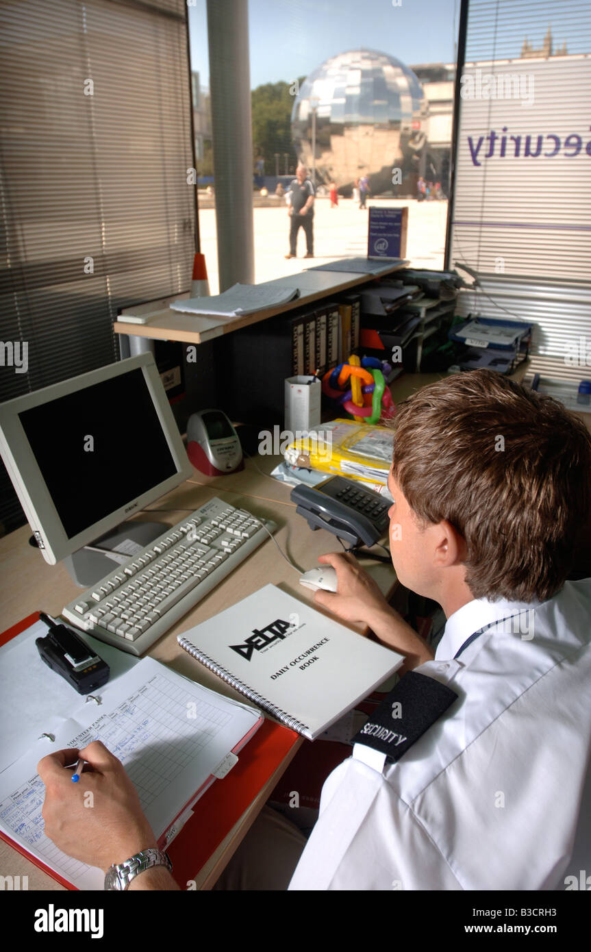 A SECURITY GUARD LOGS INFORMATION AT AN OFFICE DESK UK Stock Photo - Alamy